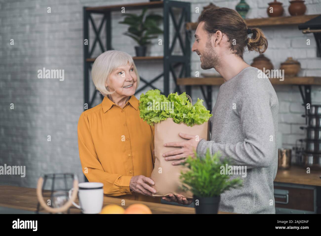 Young smiling man and his mom getting ready for dinner Stock Photo - Alamy