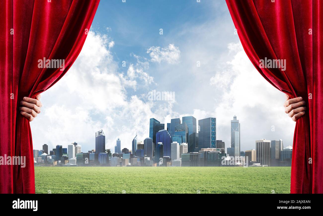 Green meadow behind red curtain and hand holding it Stock Photo - Alamy