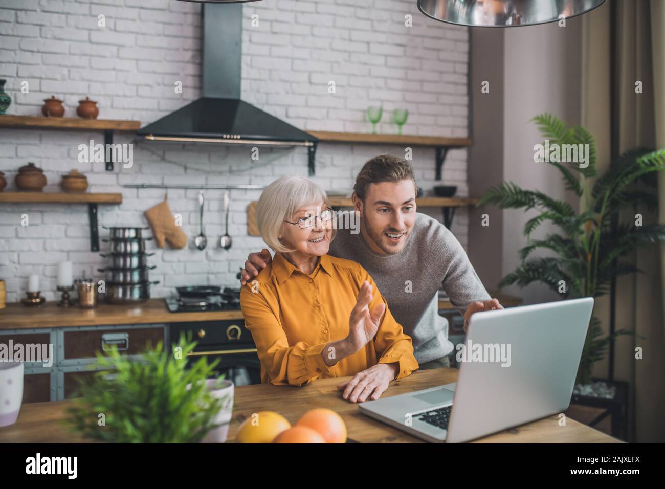 Young handsome man in grey shirt and his mom looking happy Stock Photo ...
