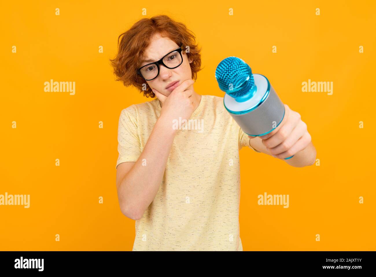 young smart thinking red-haired guy leading in a T-shirt and glasses on ...