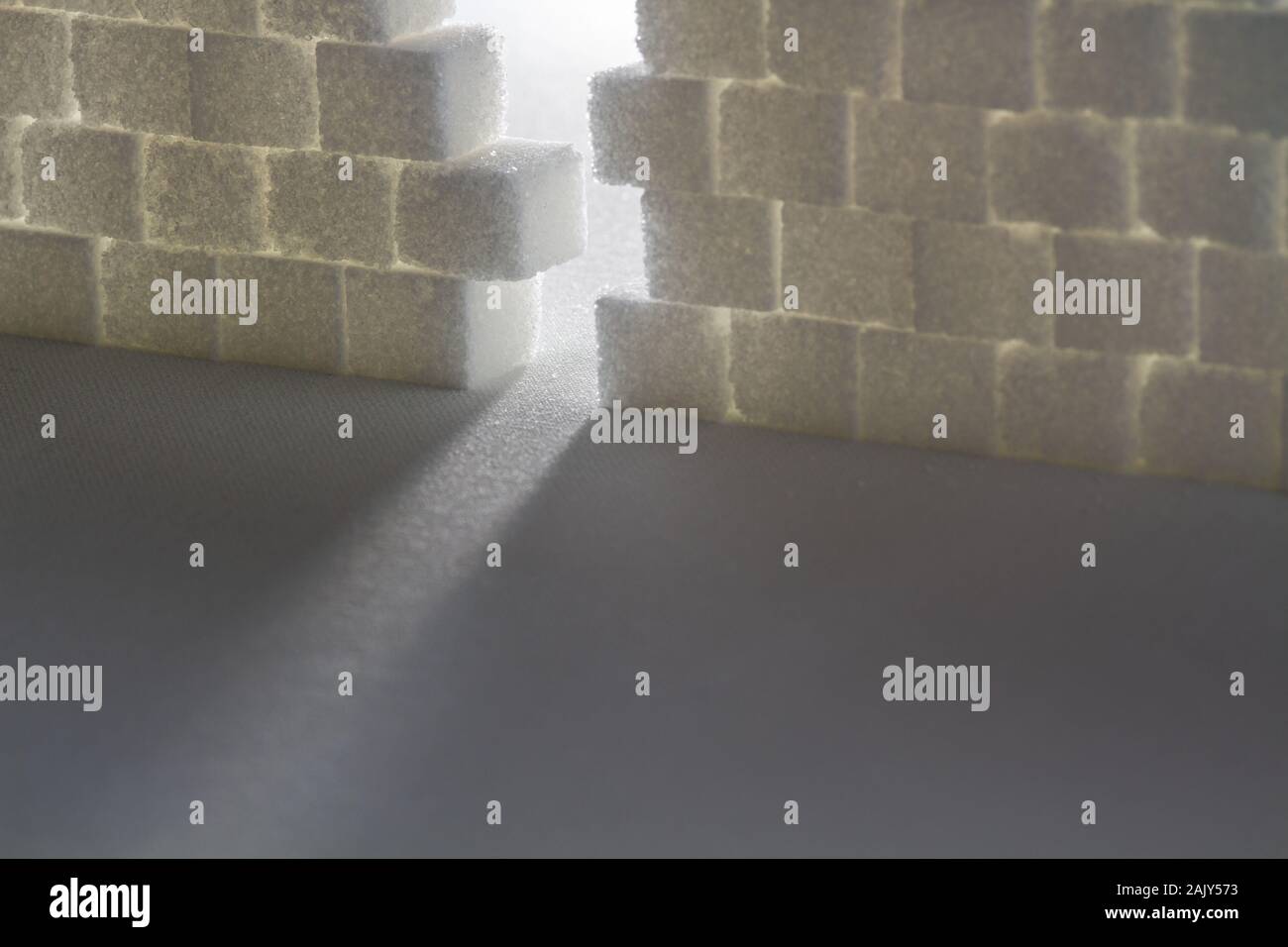 light shining through gap in a wall made out of sugar cubes ...