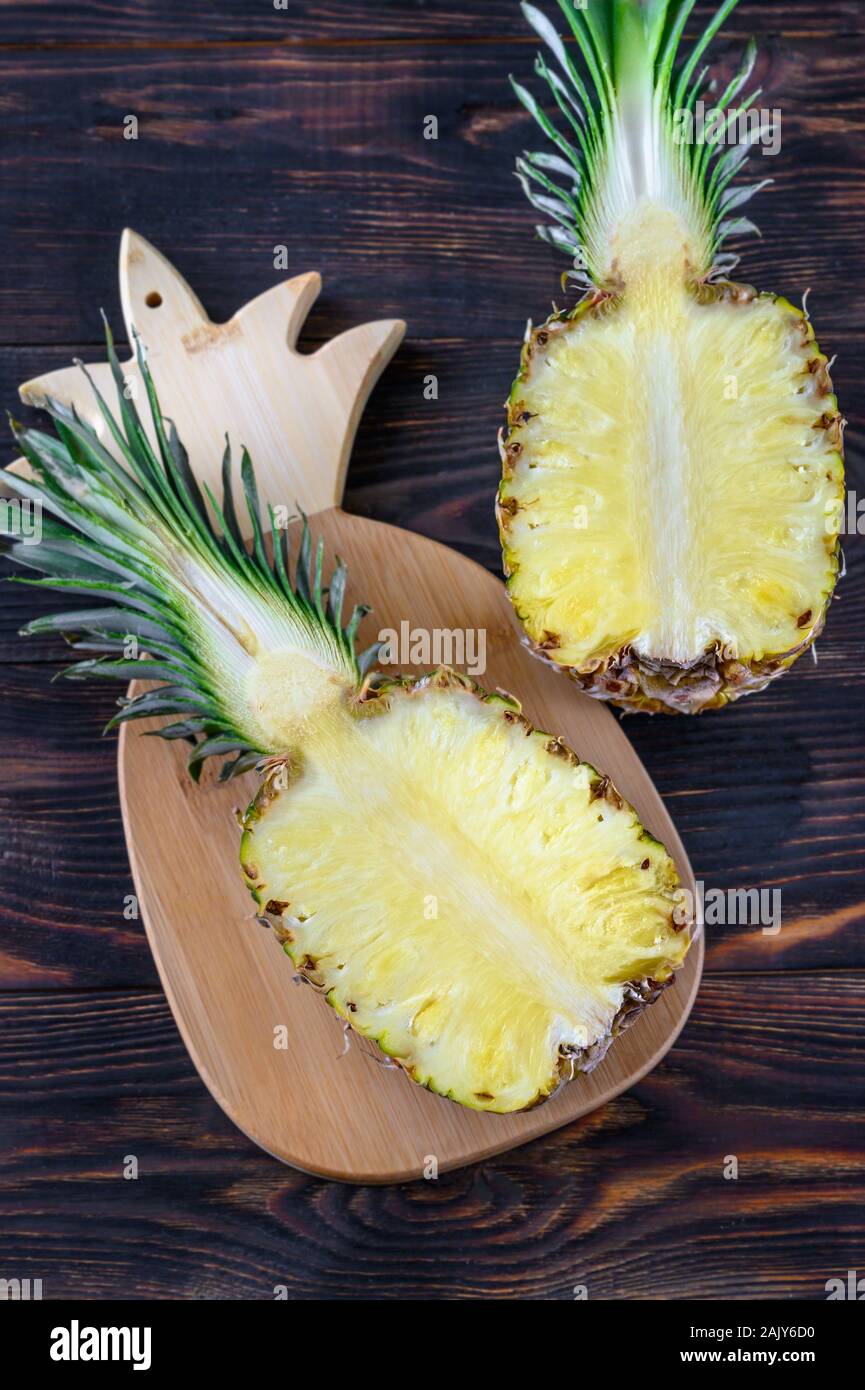 Pineapple on the wooden board: cross section Stock Photo - Alamy