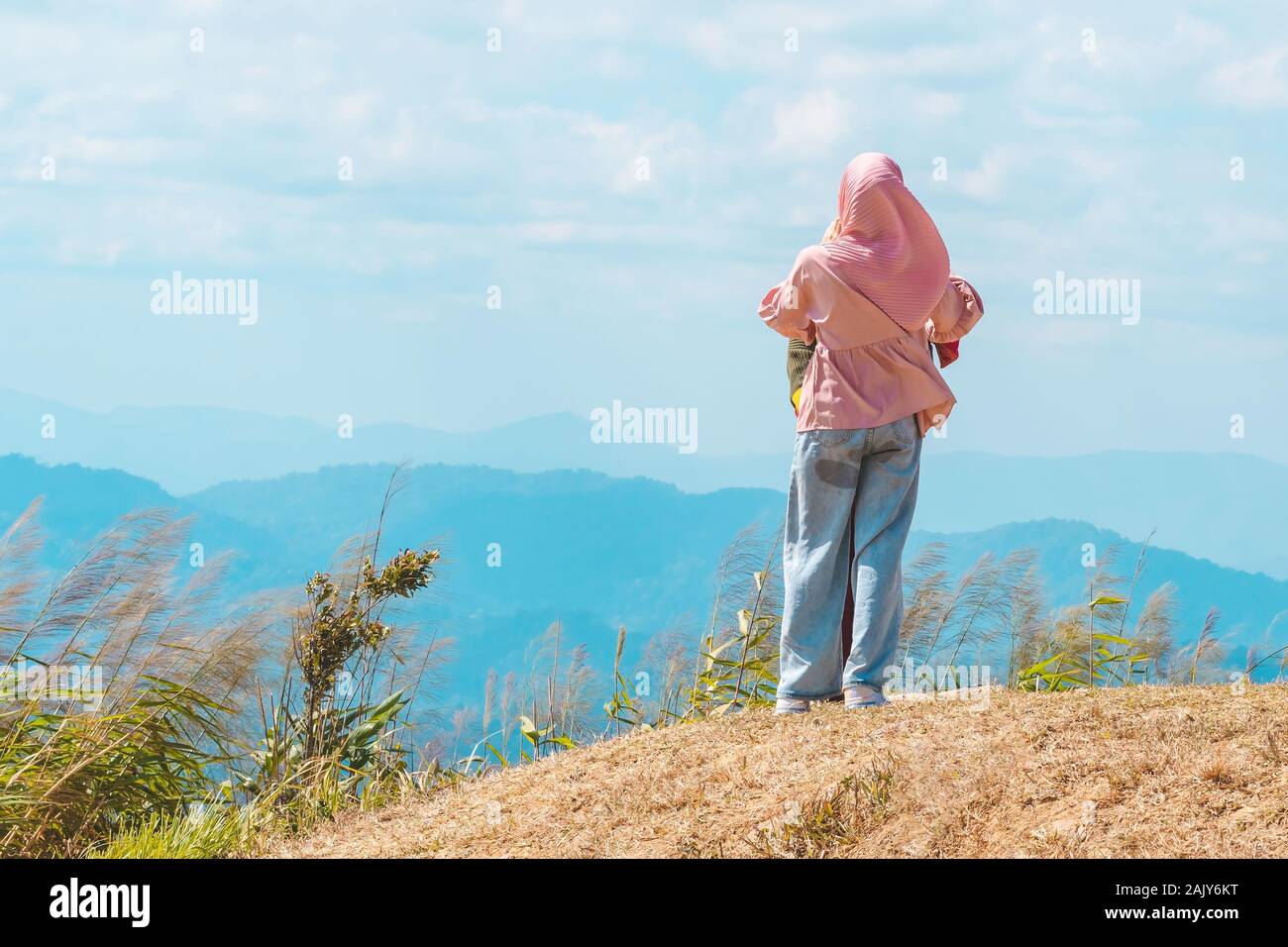Back view of Muslim women wearing a Muslim dress and hijab enjoy on the ...