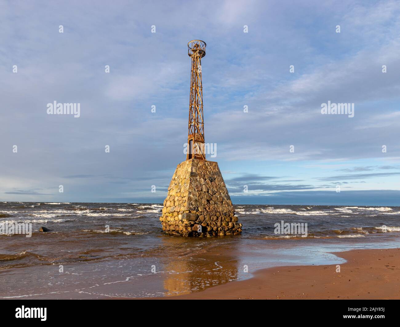 landscape with old and crooked lighthouse by the sea, windy day by the ...