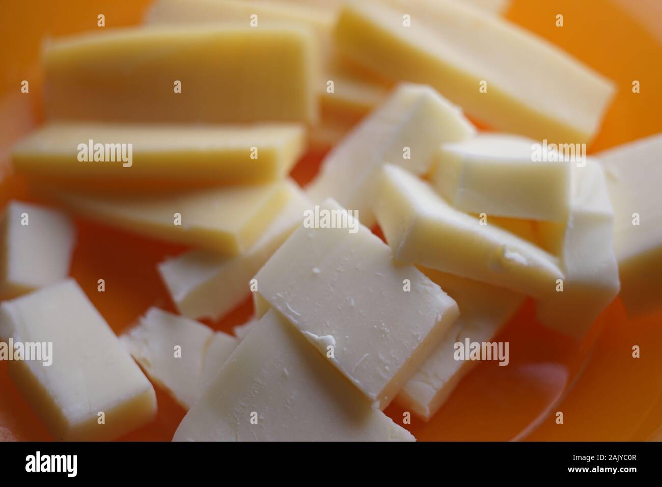 Two kinds of hard cheese on a plate close-up, rectangular slices of ...