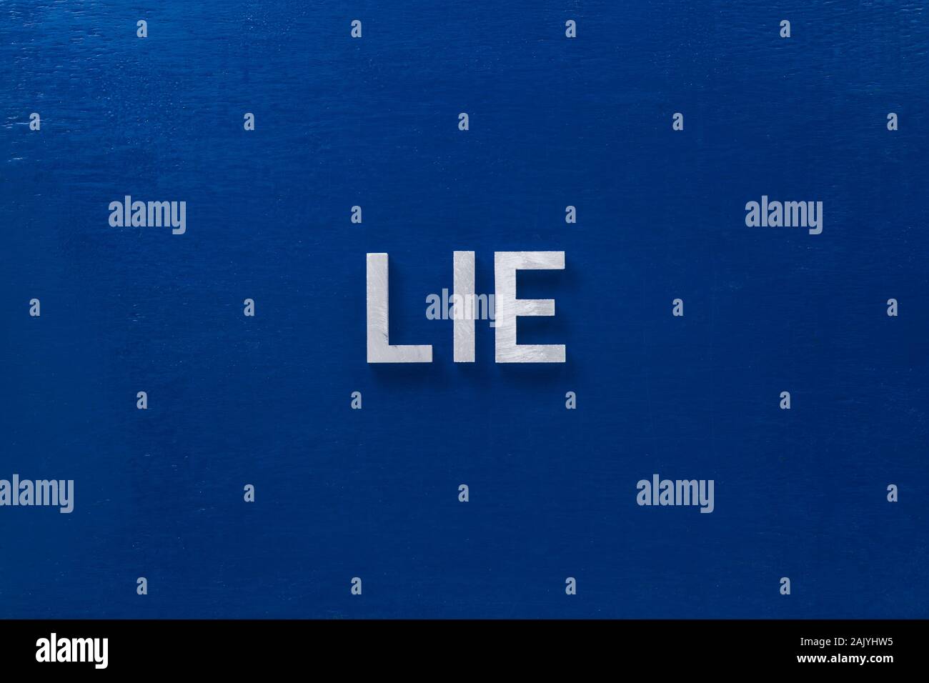 the word lies laid with silver metal letters on classic blue board in ...