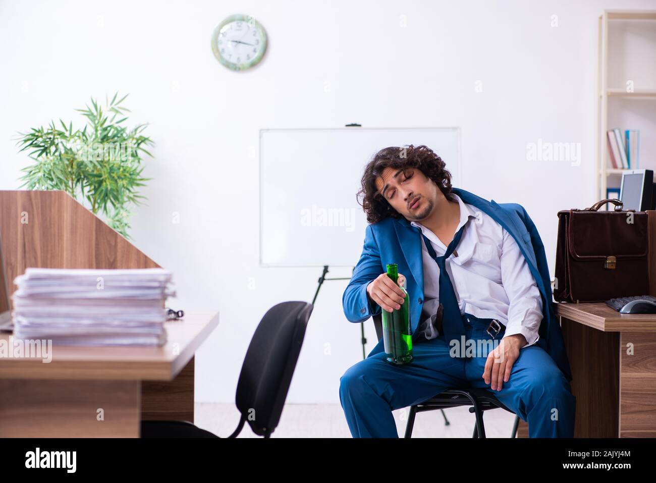 The young drunk employee in the office Stock Photo - Alamy