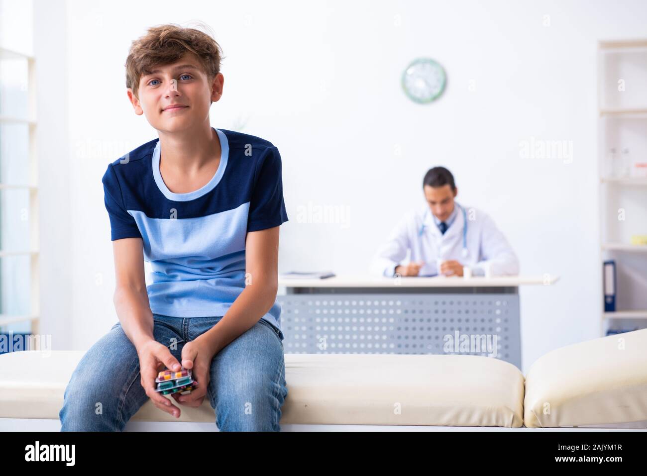 The young male doctor examining boy in the clinic Stock Photo - Alamy