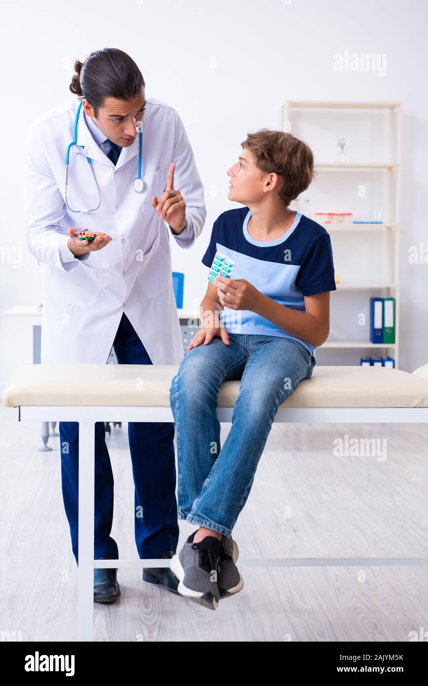 The young male doctor examining boy in the clinic Stock Photo - Alamy