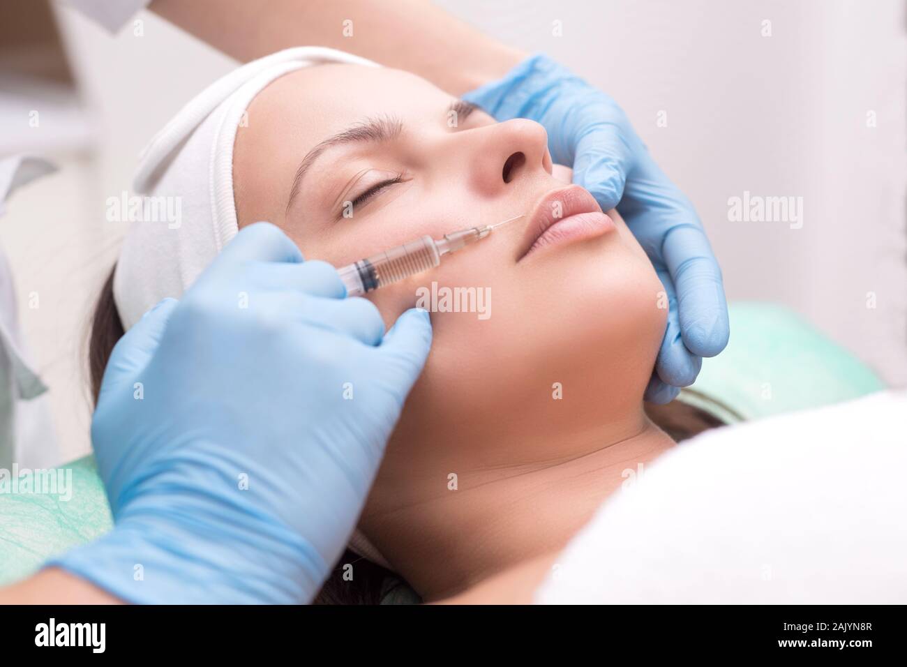 injection into the skin of the face of a young woman, close-up. A ...