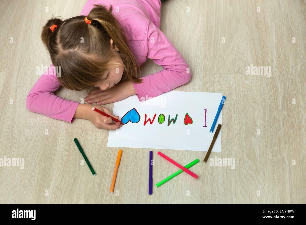 View from above of cute child girl drawing with colorful crayons I love ...