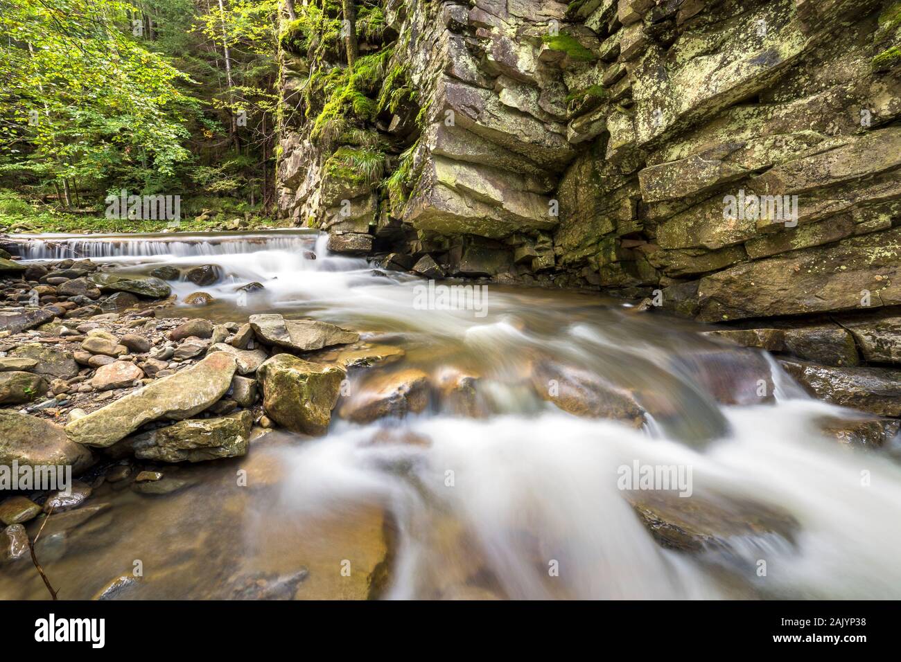 Fast flowing river stream with smooth silky water falling from big ...