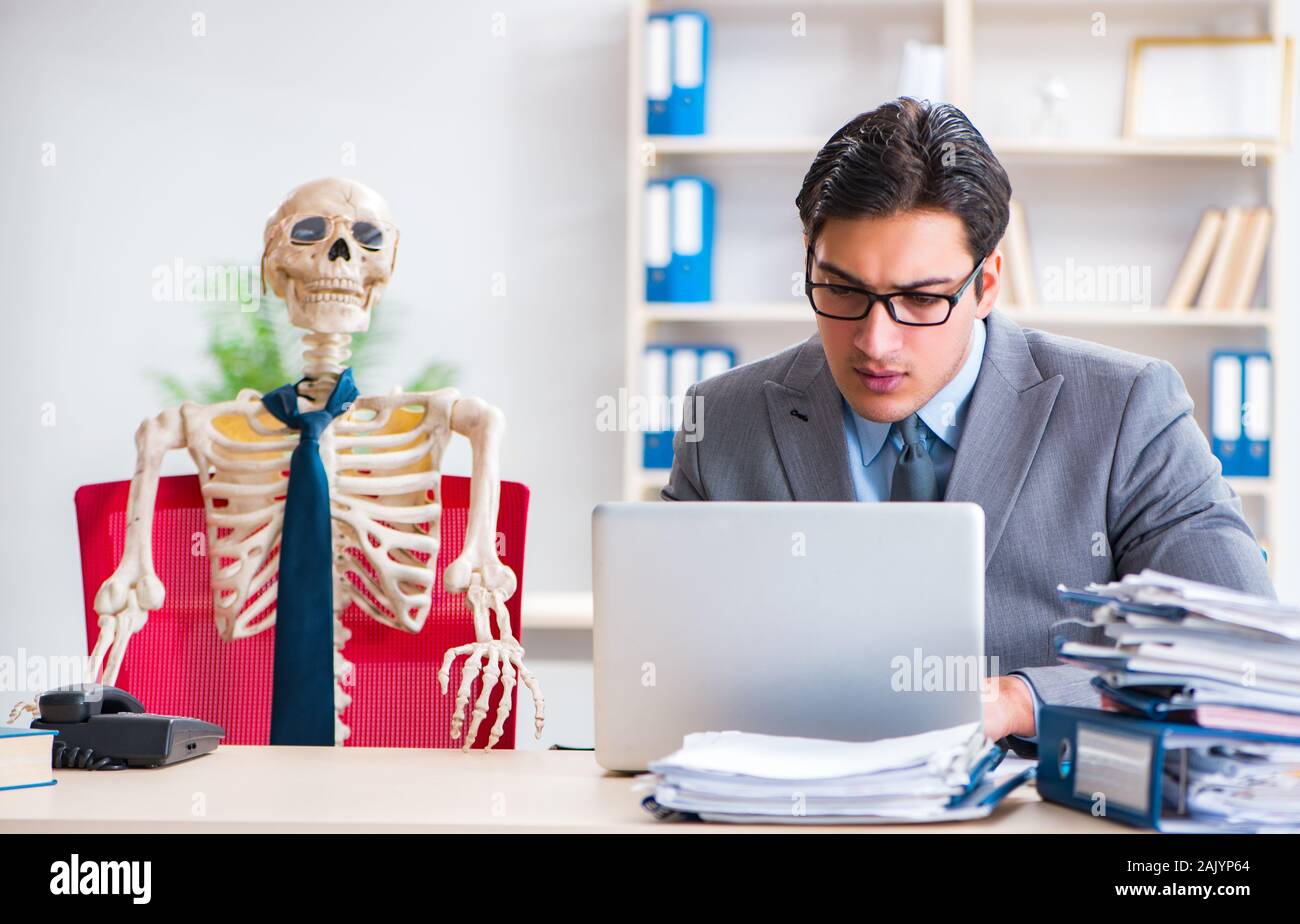 The businessman working with skeleton in office Stock Photo - Alamy