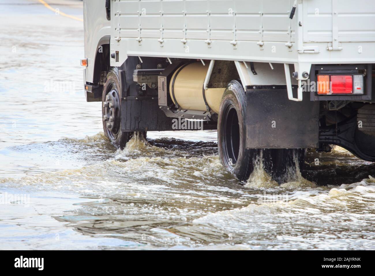 Car splashes through a large puddle on a flooded street Stock Photo - Alamy