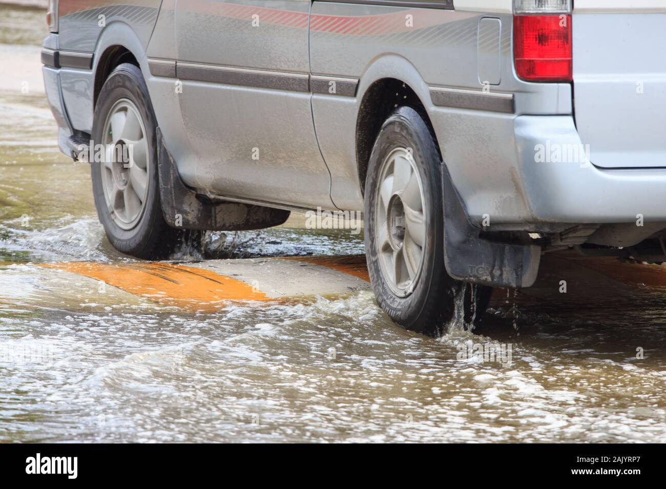 Car splashes through a large puddle on a flooded street Stock Photo - Alamy