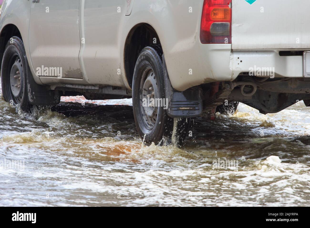 Splash by a car as it goes through flood water Stock Photo - Alamy