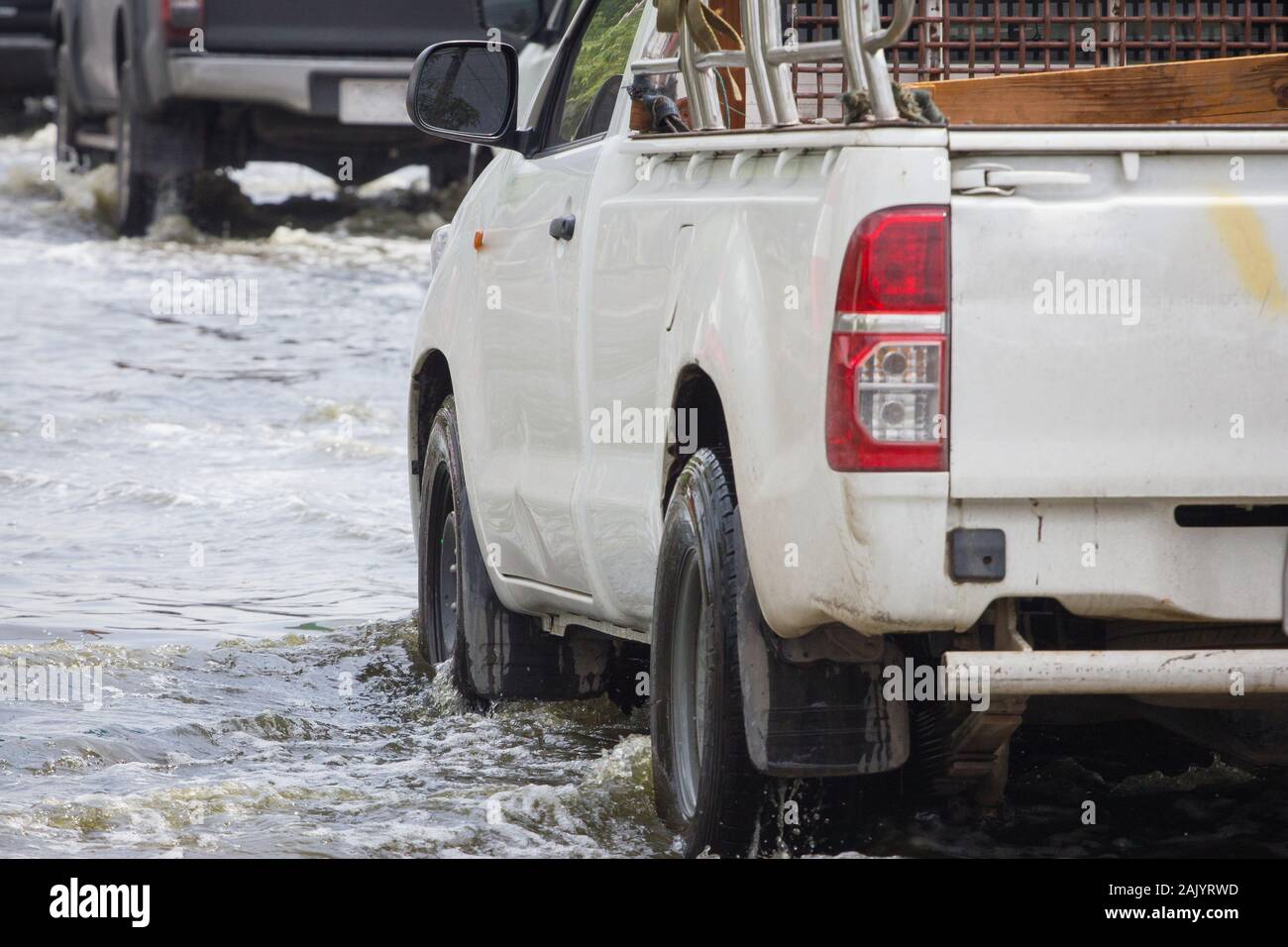 Splash by a car as it goes through flood water Stock Photo - Alamy
