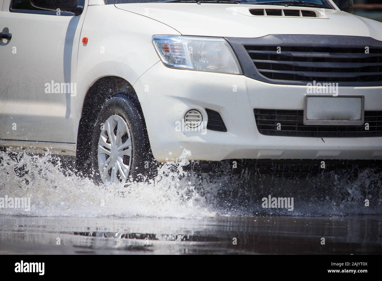 Splash by a car as it goes through flood water Stock Photo - Alamy