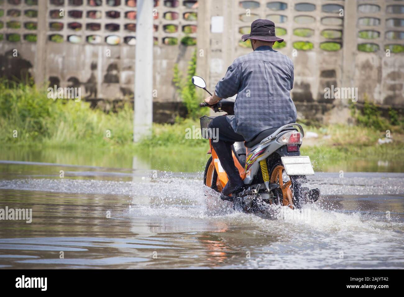 Splash by a motorcycle as it goes through flood water Stock Photo - Alamy