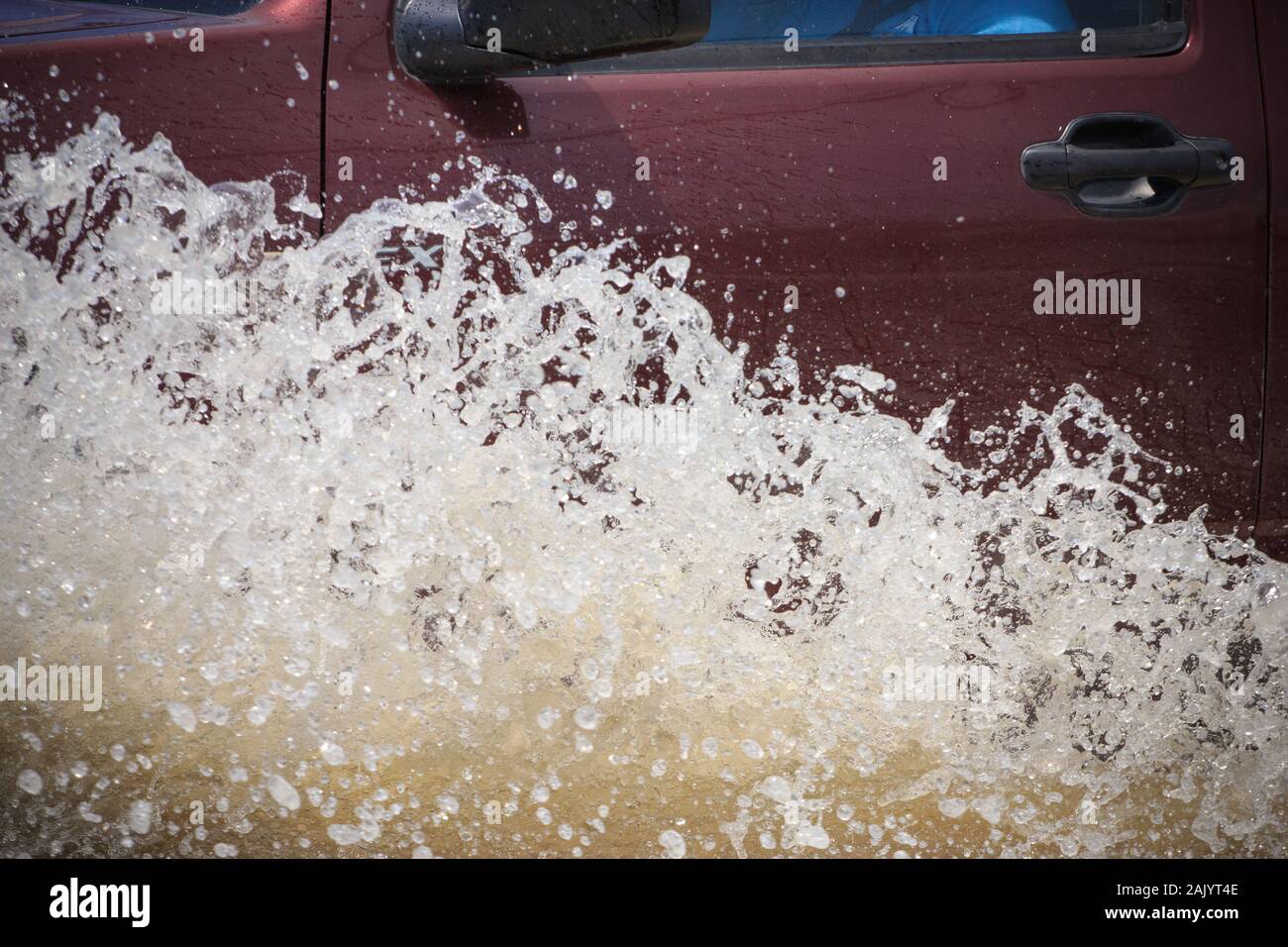Splash by a car as it goes through flood water Stock Photo - Alamy