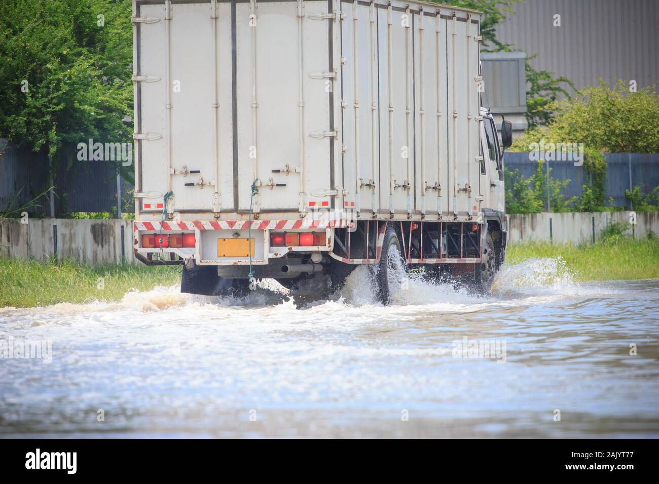 Splash by a truck as it goes through flood water Stock Photo - Alamy