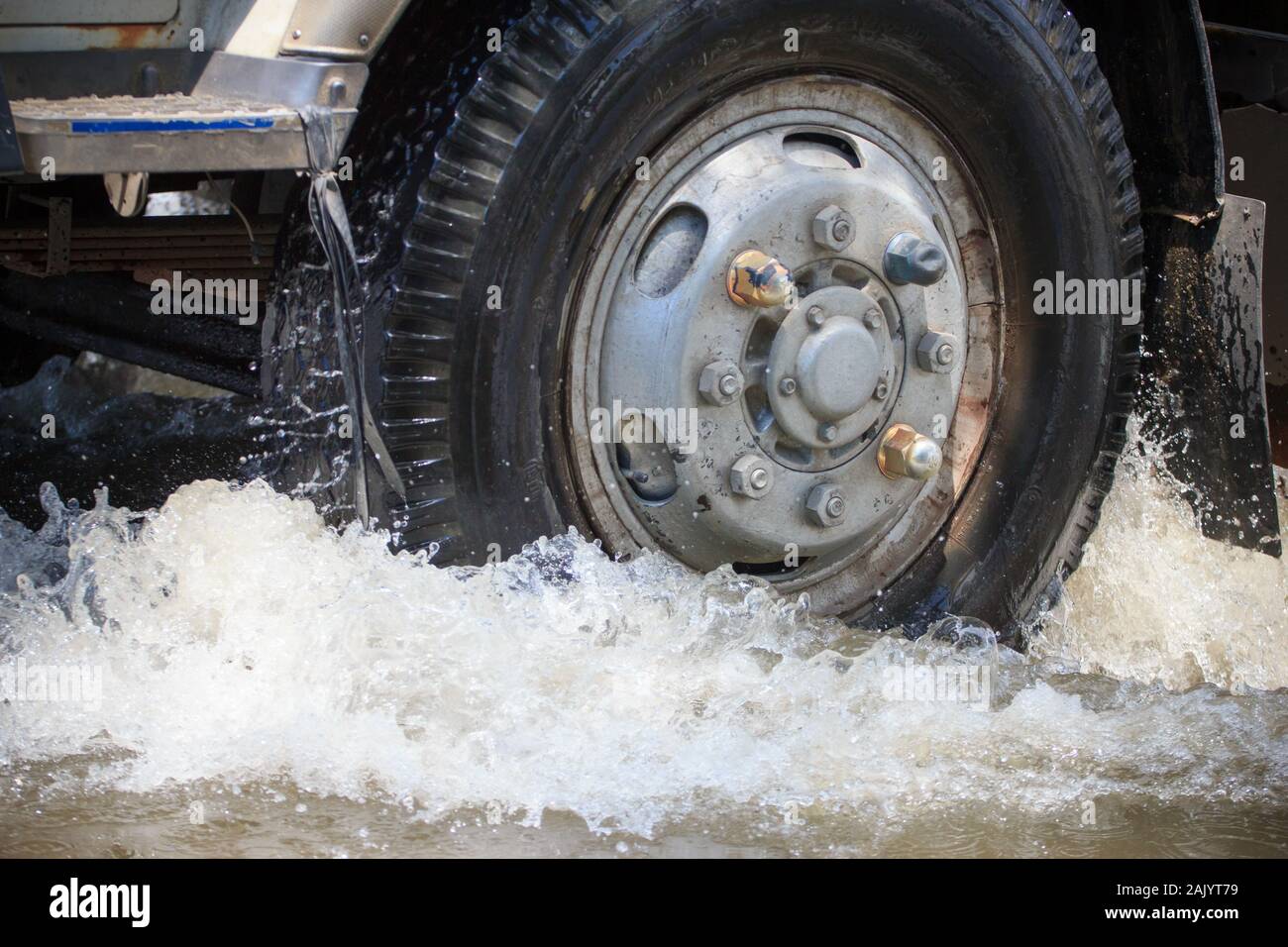 Splash by a car as it goes through flood water Stock Photo - Alamy