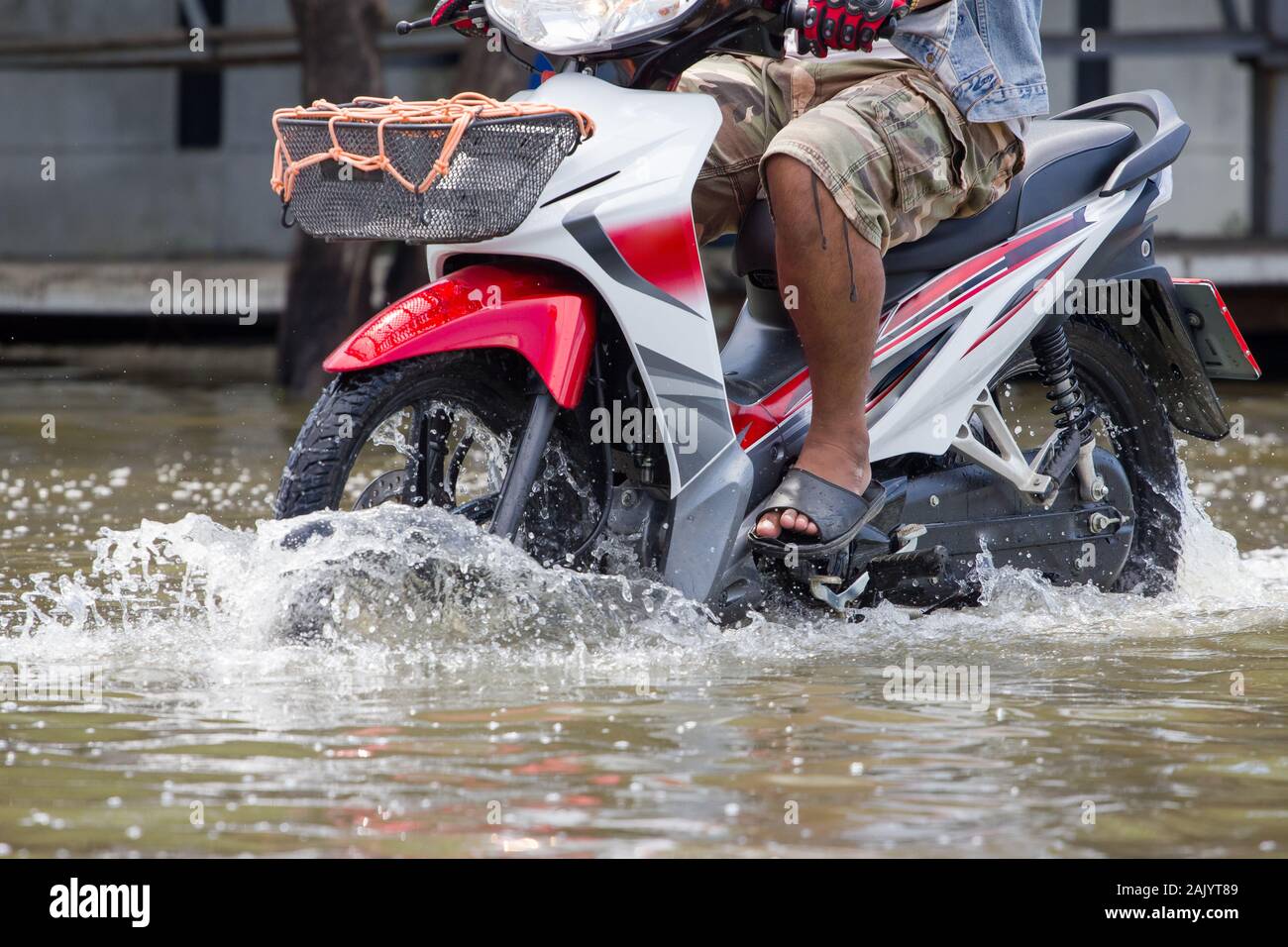 Splash by a motorcycle as it goes through flood water Stock Photo - Alamy