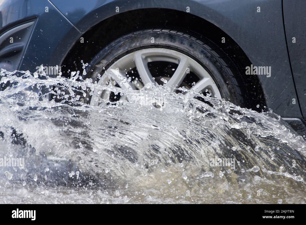 Car splashes through a large puddle on a flooded street Stock Photo - Alamy