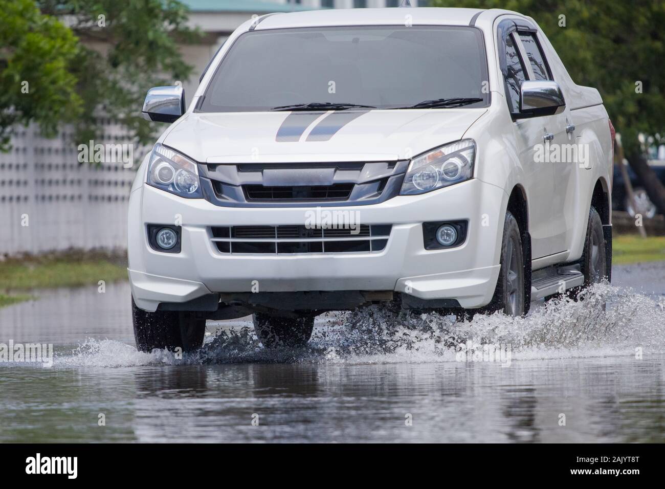 Car splashes through a large puddle on a flooded street Stock Photo - Alamy