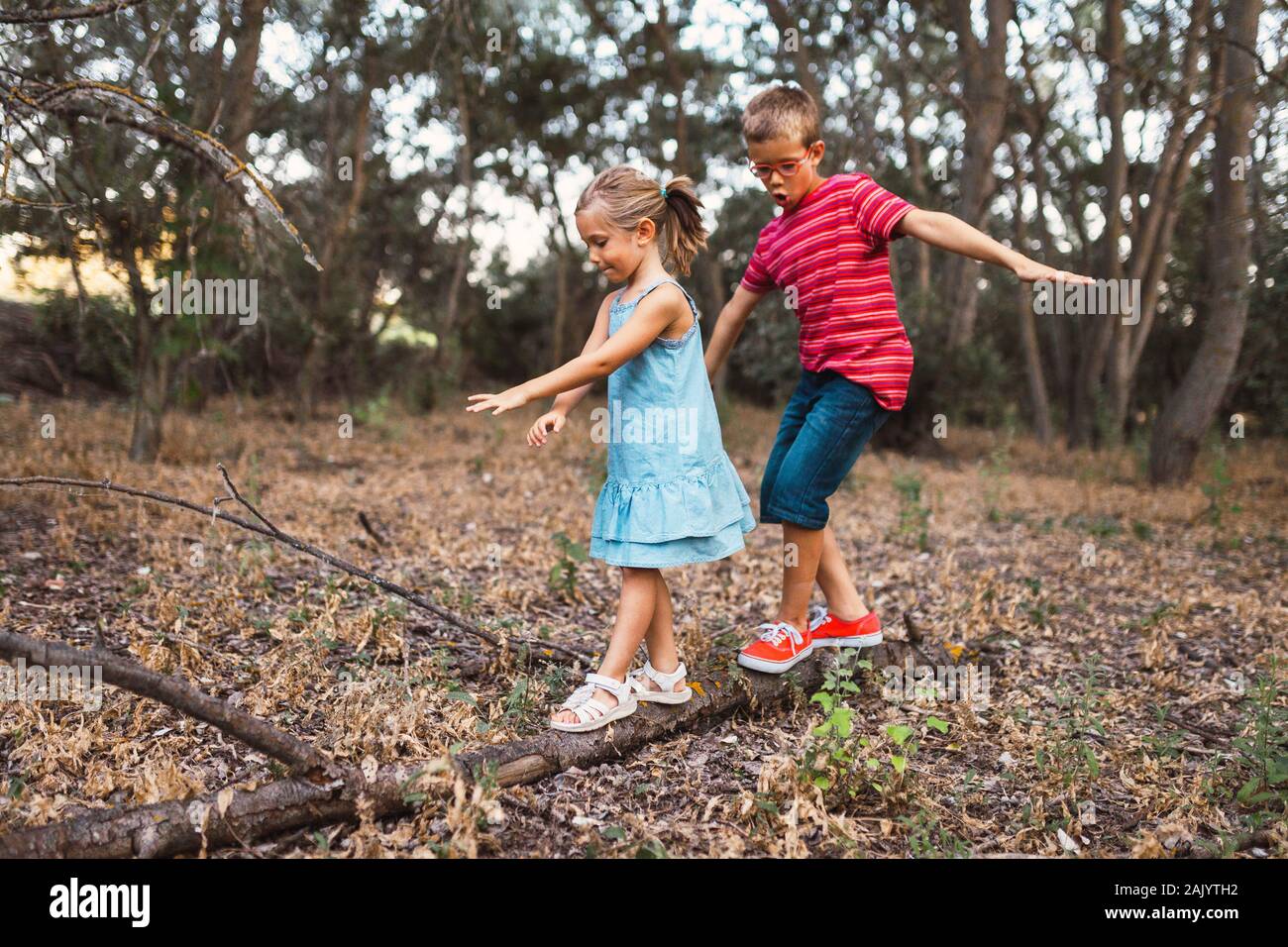Two kids playing in the forest Stock Photo - Alamy