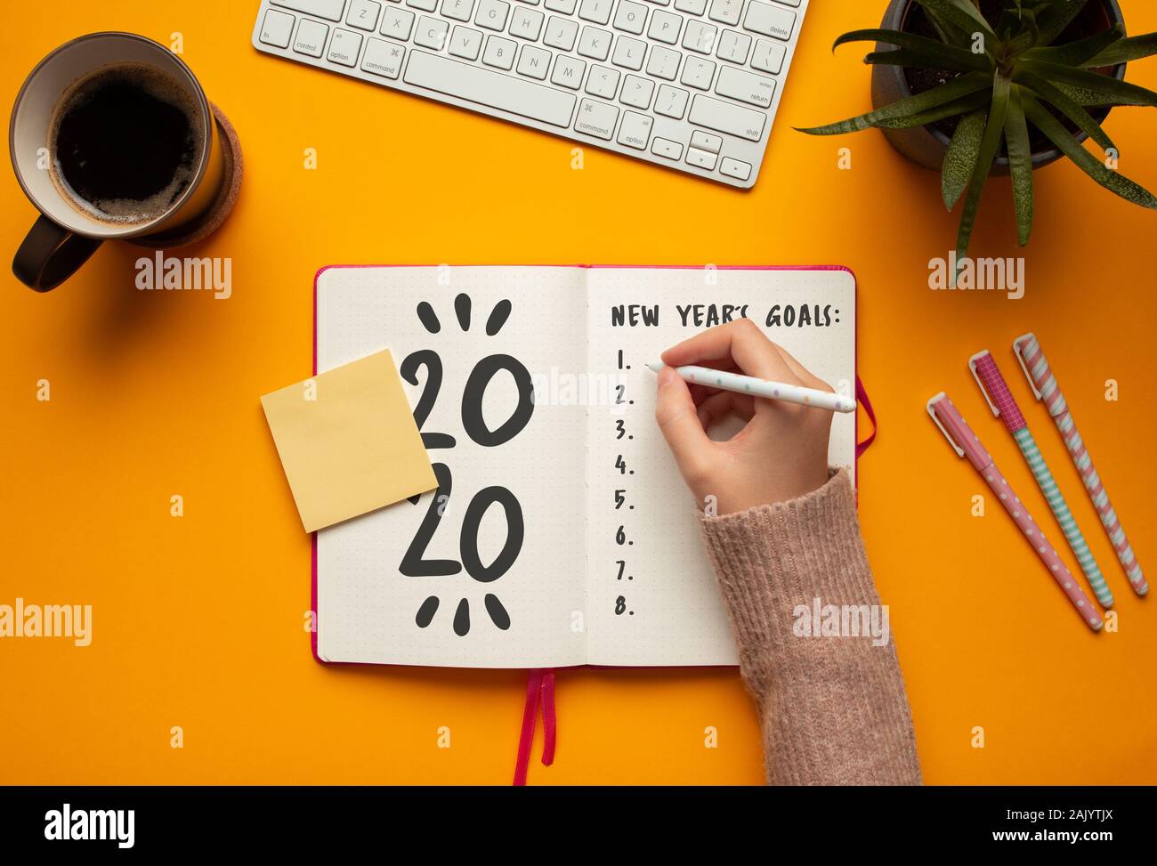 Stock photo of a young woman hand writing in a 2020 new year notebook ...