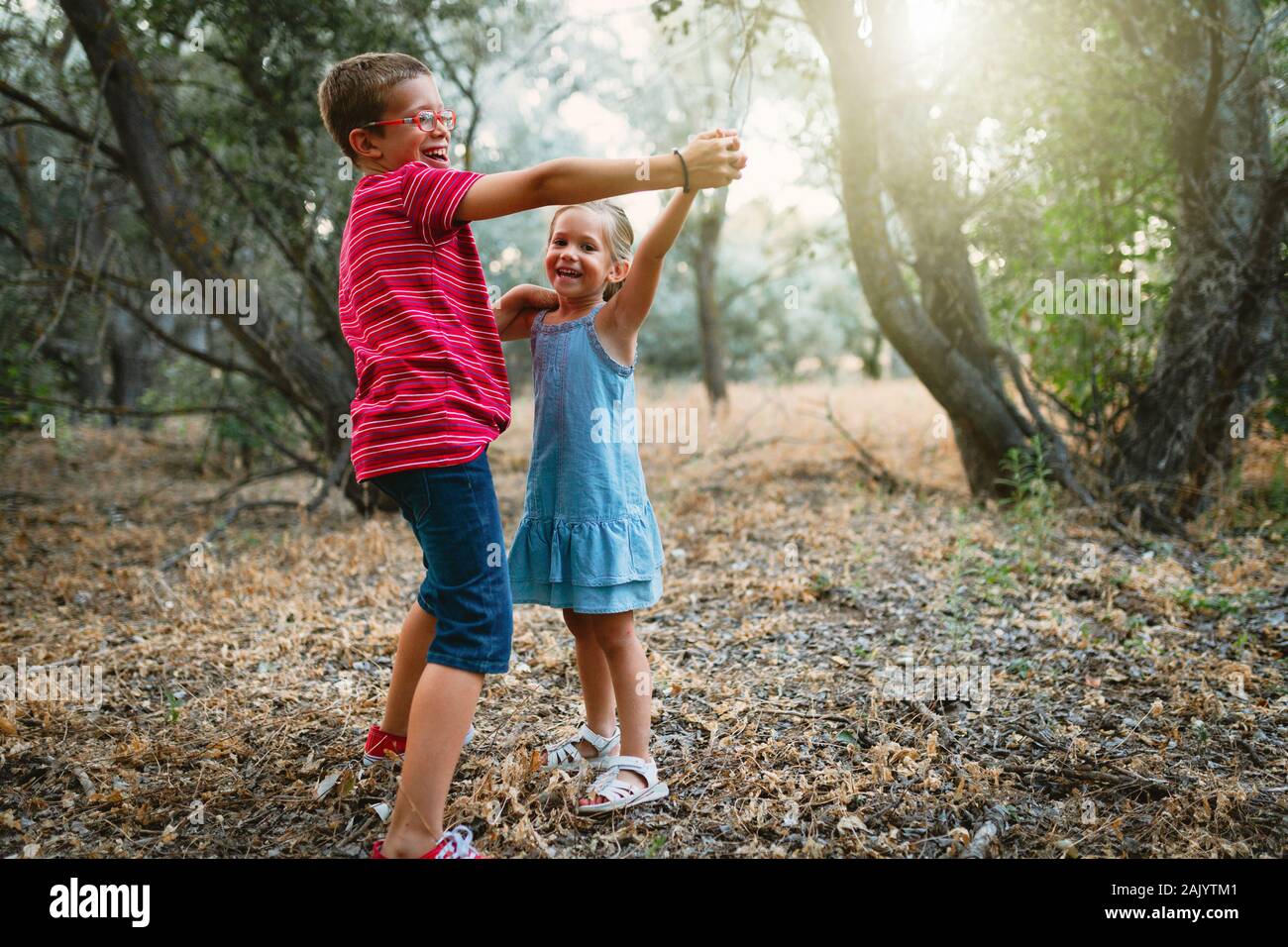 Two kids playing and dancing in the forest Stock Photo - Alamy
