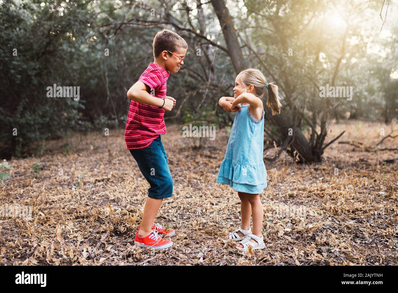Two kids playing and dancing in the forest Stock Photo - Alamy