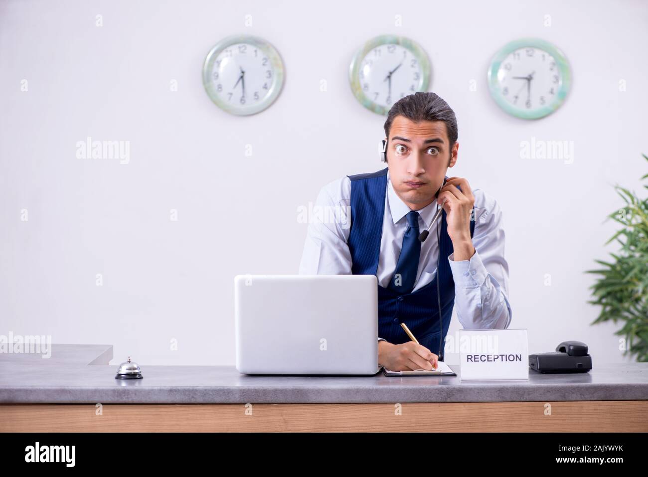 The young man receptionist at the hotel counter Stock Photo - Alamy
