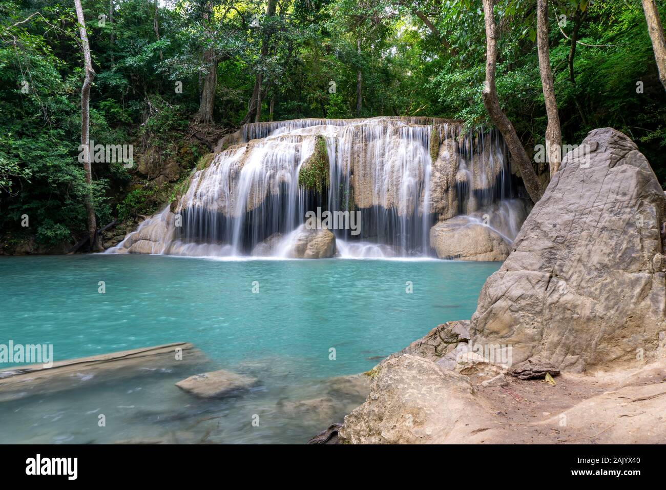 Clean green emerald water from the waterfall Surrounded by small trees ...
