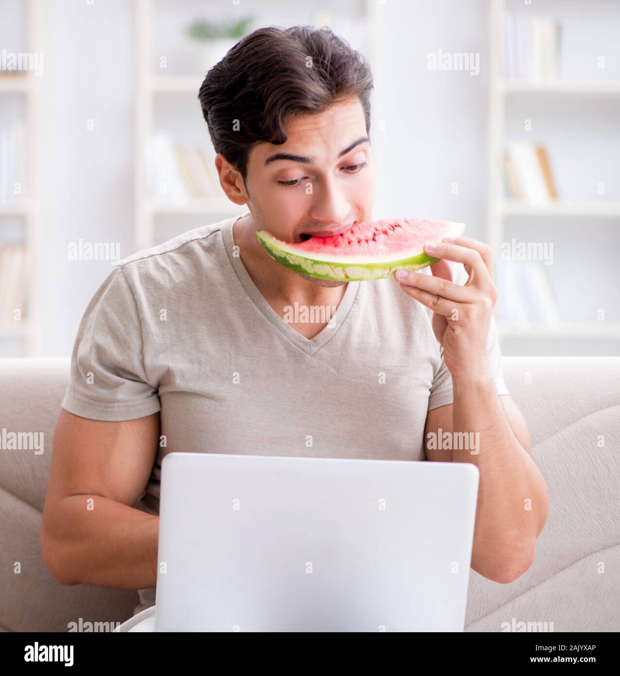 The man eating watermelon at home Stock Photo - Alamy