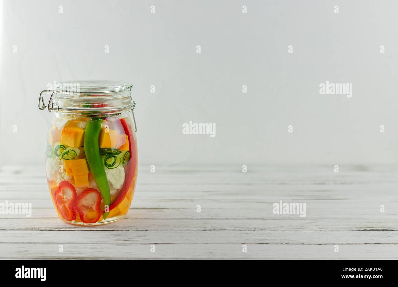 glass jar of fermented vegetables on a light background. fermentation ...