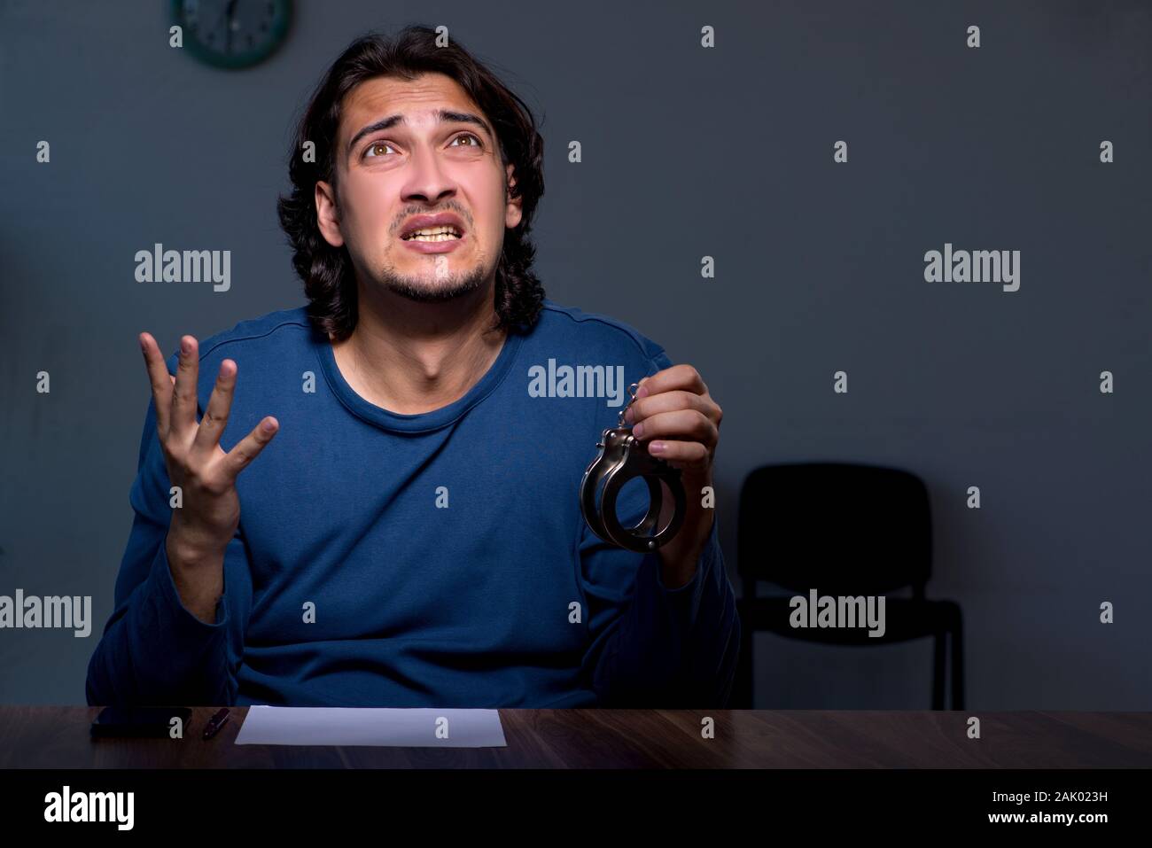 The young convict man sitting in dark room Stock Photo - Alamy