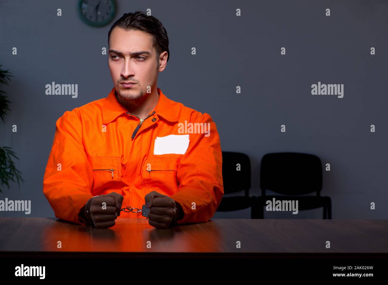 The young convict man sitting in dark room Stock Photo - Alamy