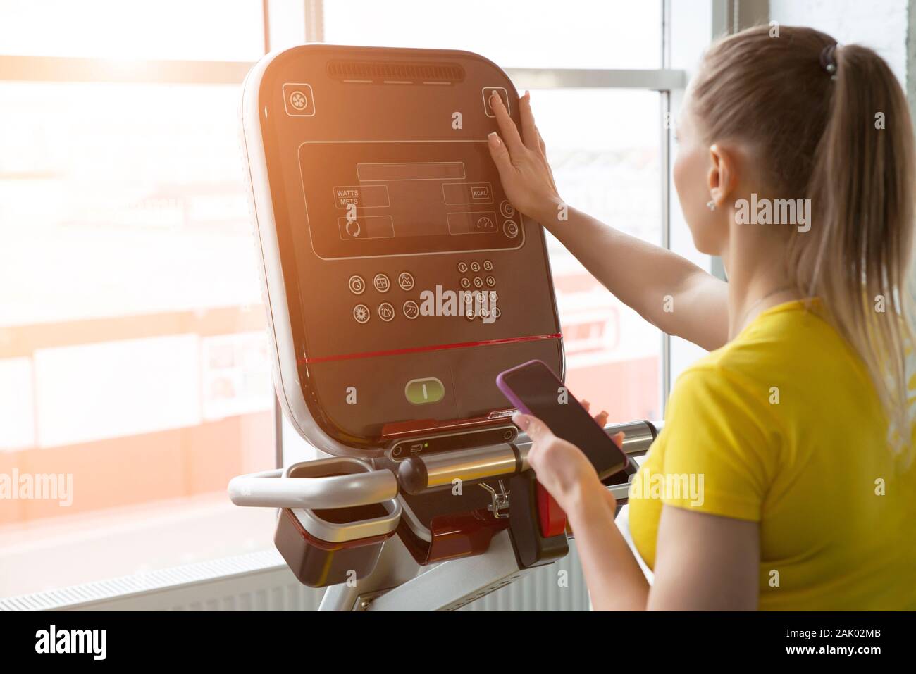 Woman adjusting settings on training machine in gym Stock Photo - Alamy