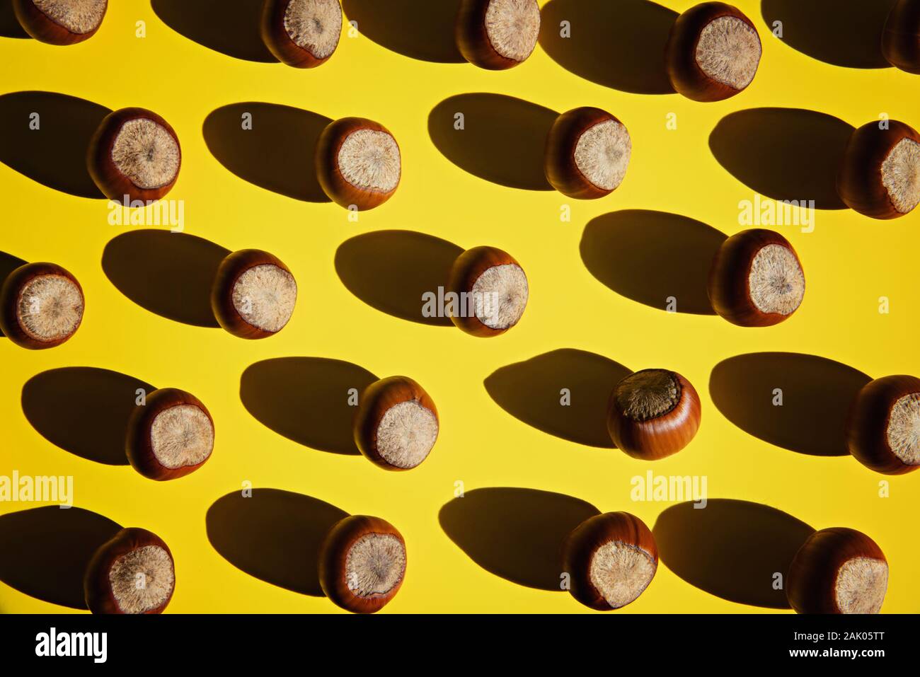 Unpeeled hazelnuts with contrast of light and shadows on a yellow ...