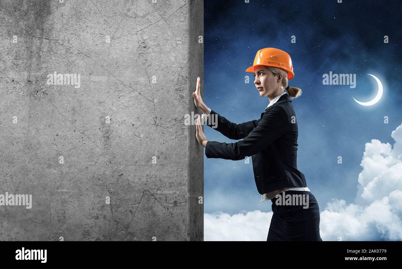 Beautiful woman architect pushing concrete wall Stock Photo - Alamy