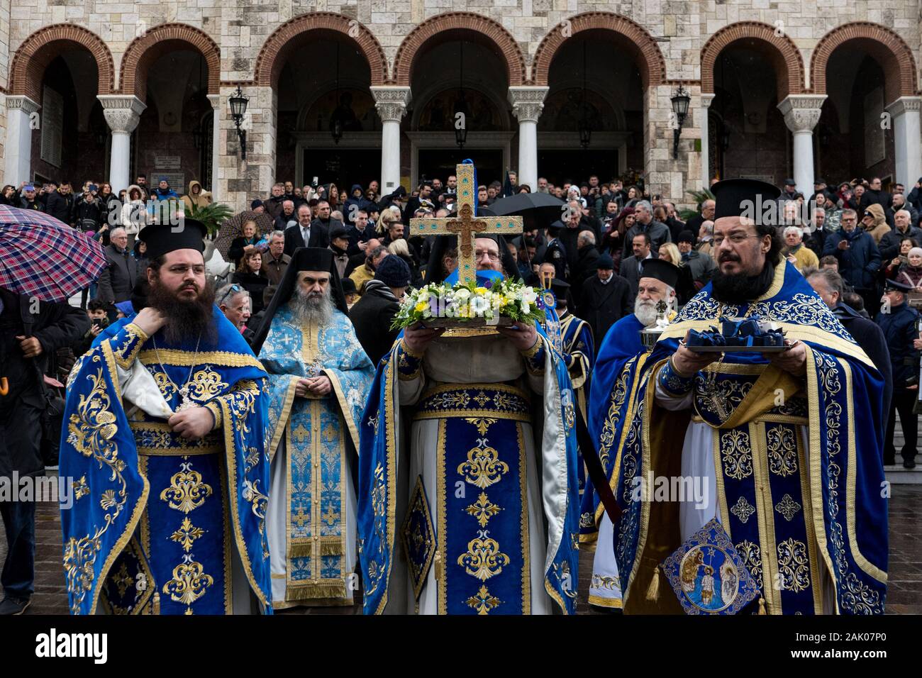An Orthodox priest holds a wooden cross during the Epiphany day ...