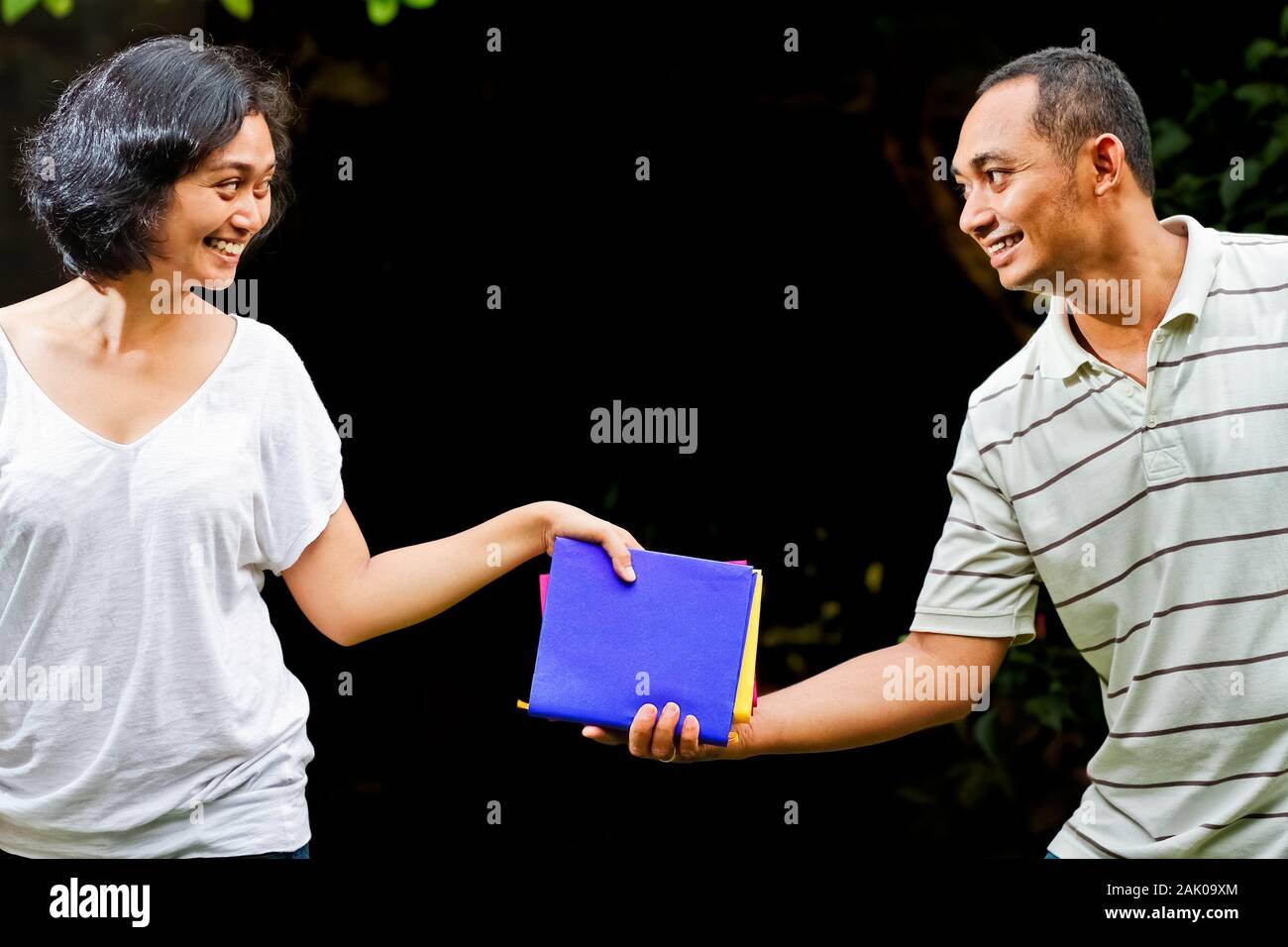 ethnic asian students hand over stack of books Stock Photo - Alamy