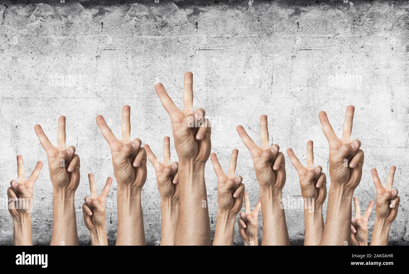 Row of man hands showing victory gesture Stock Photo - Alamy