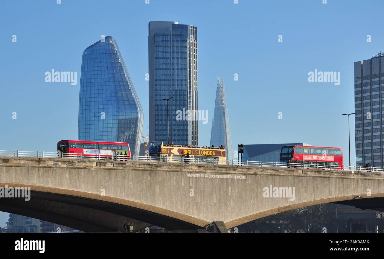 Buses crossing Waterloo Bridge with skyscrapers behind, London, England ...