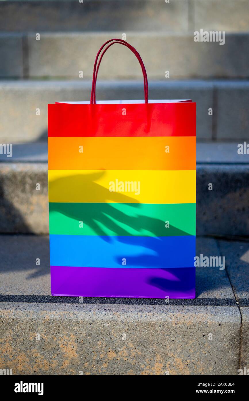 Shadow of two hands clutching on a Pride bag. LGBT and Pride couple ...