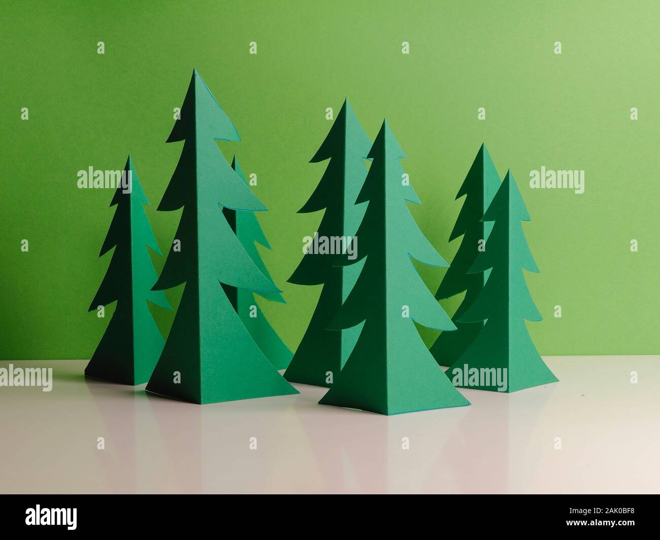 Paper trees simulating a forest over a green background. Studio shoot ...