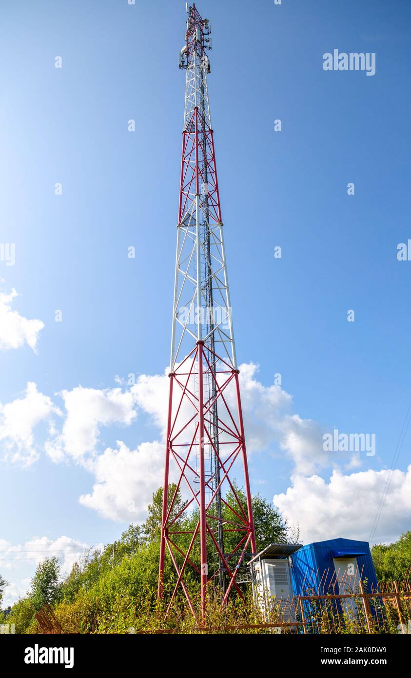Telecommunication tower for mobile phone with antennas over a blue sky. Distribution function of ...