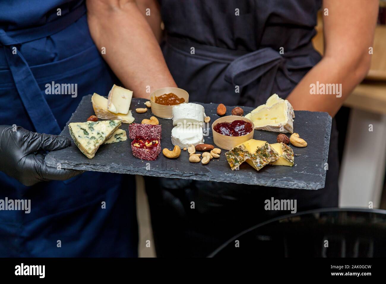 A cheese plate with an assortment of various types of cheese on a dark ...